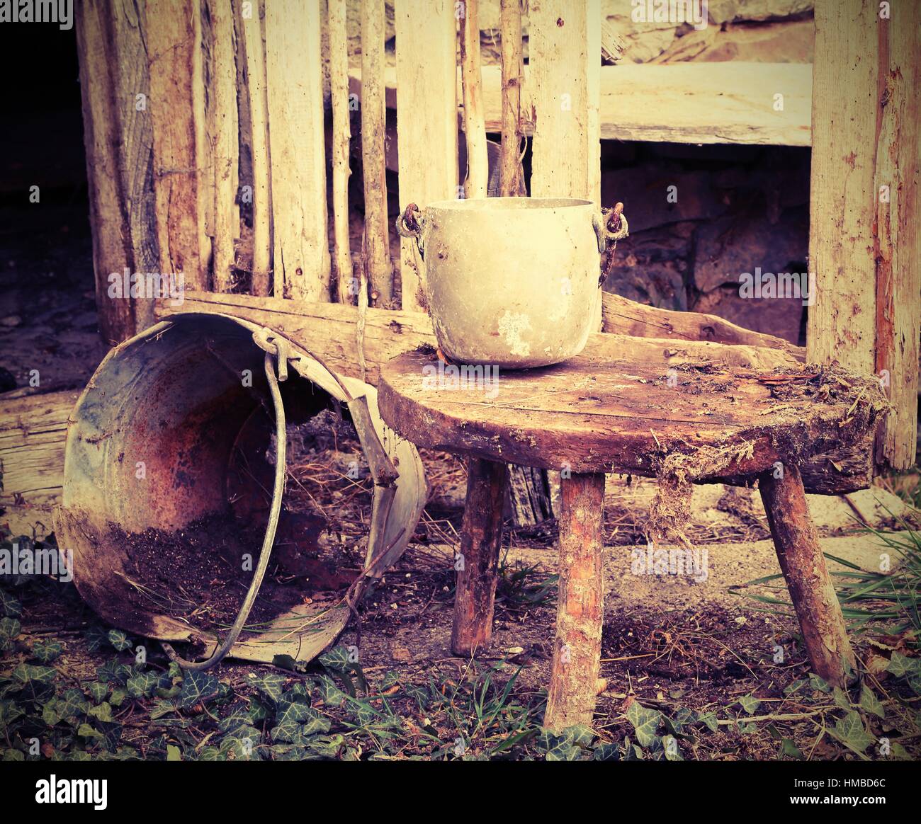 old broken bucket and an aluminum pan on the wooden stool that was used ...
