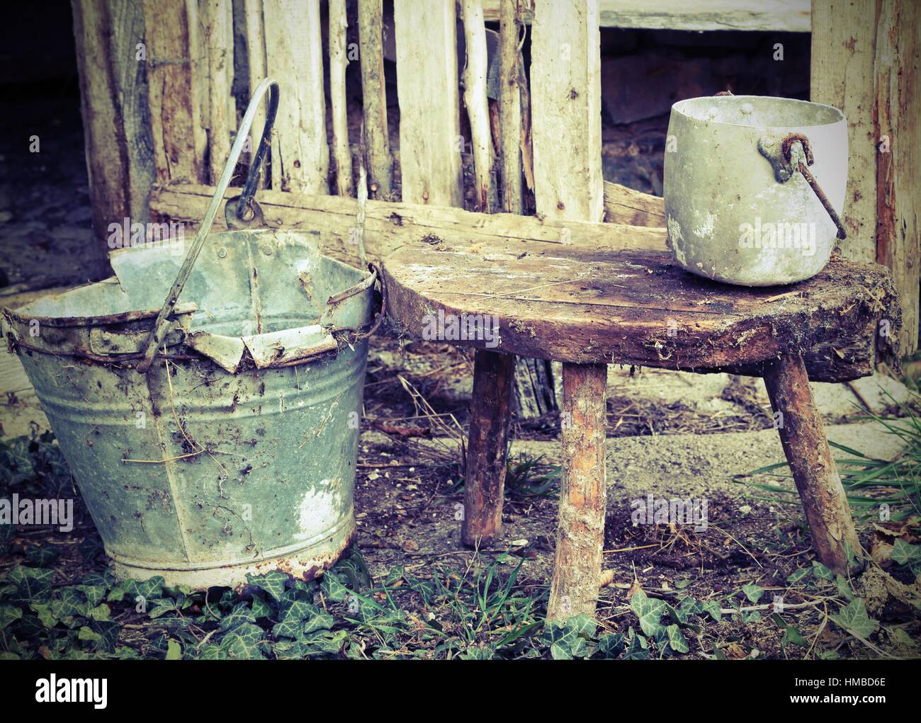 old barn an old broken bucket and an aluminum pan on the wooden stool ...