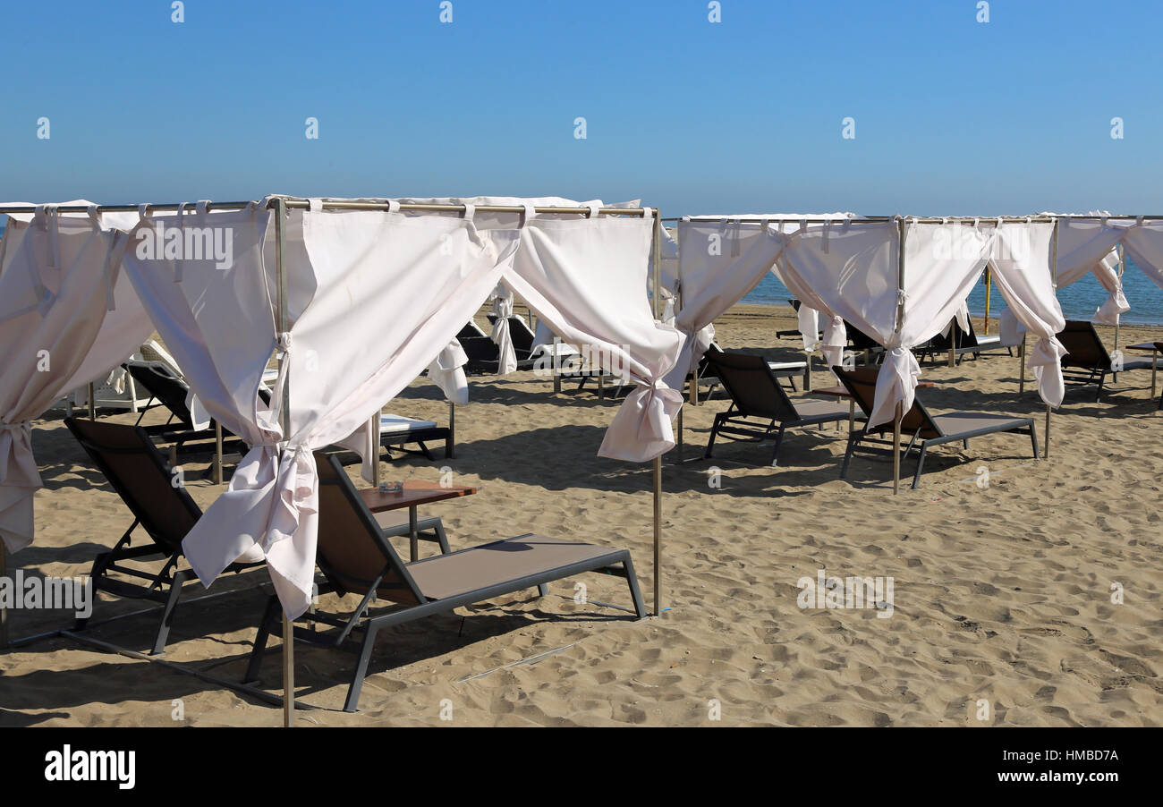 deck chairs on the beach with the curtains to shelter from the hot ...