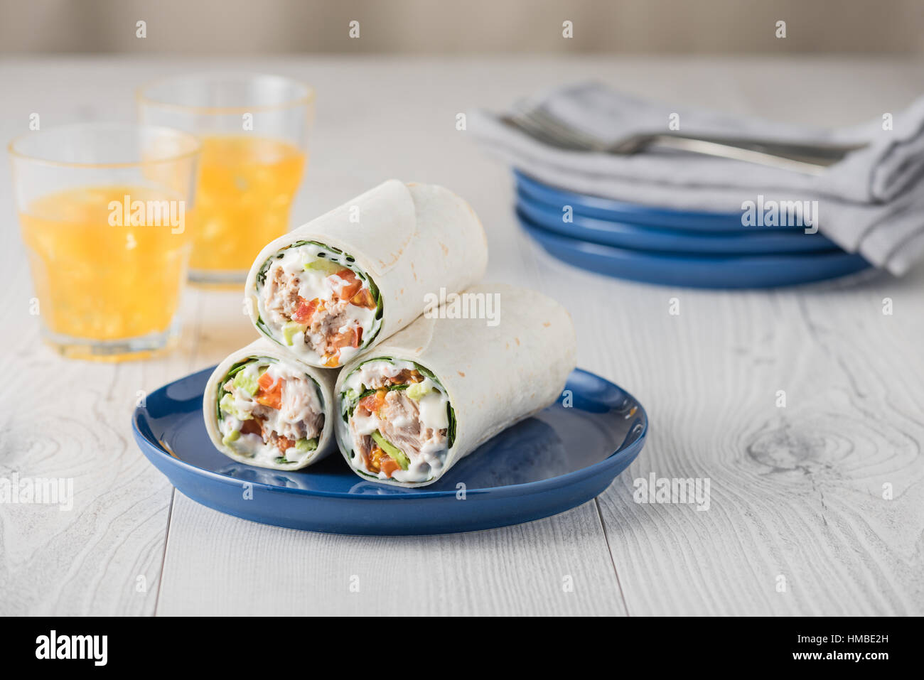 Tuna wraps with avocado tomato and mayonnaise on blue plate Stock Photo ...