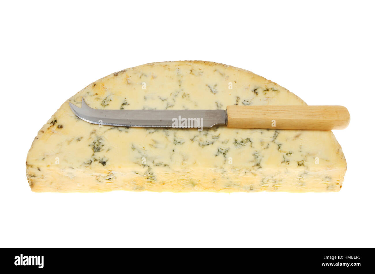 Half round of Stilton cheese with a cheese knife isolated against white ...