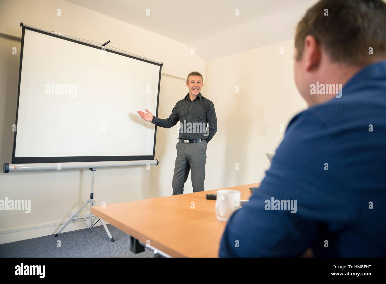 An office worker leads a training course / presentation in a plain ...