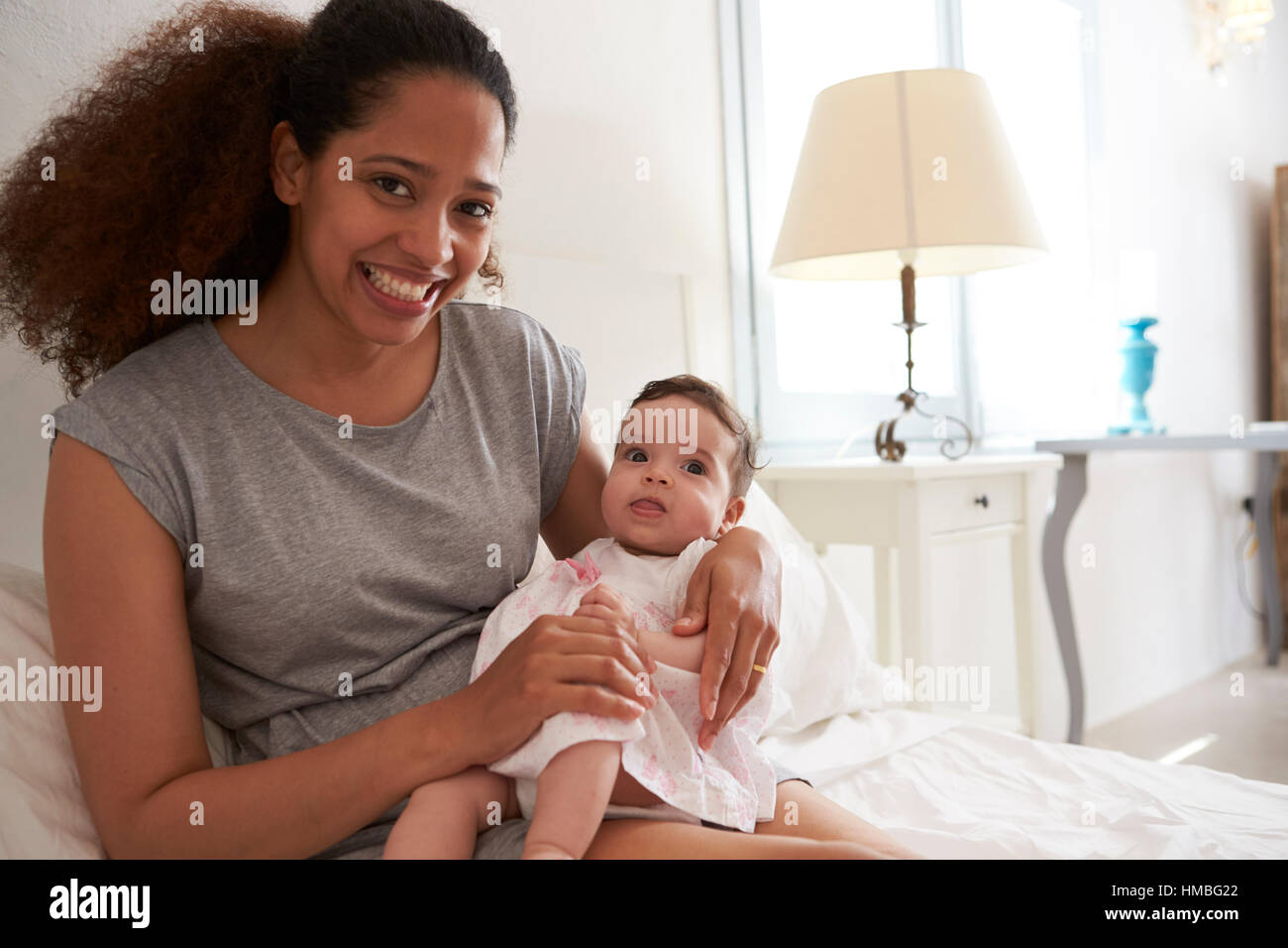 Mother Cuddling Baby Daughter In Bedroom At Home Stock Photo - Alamy