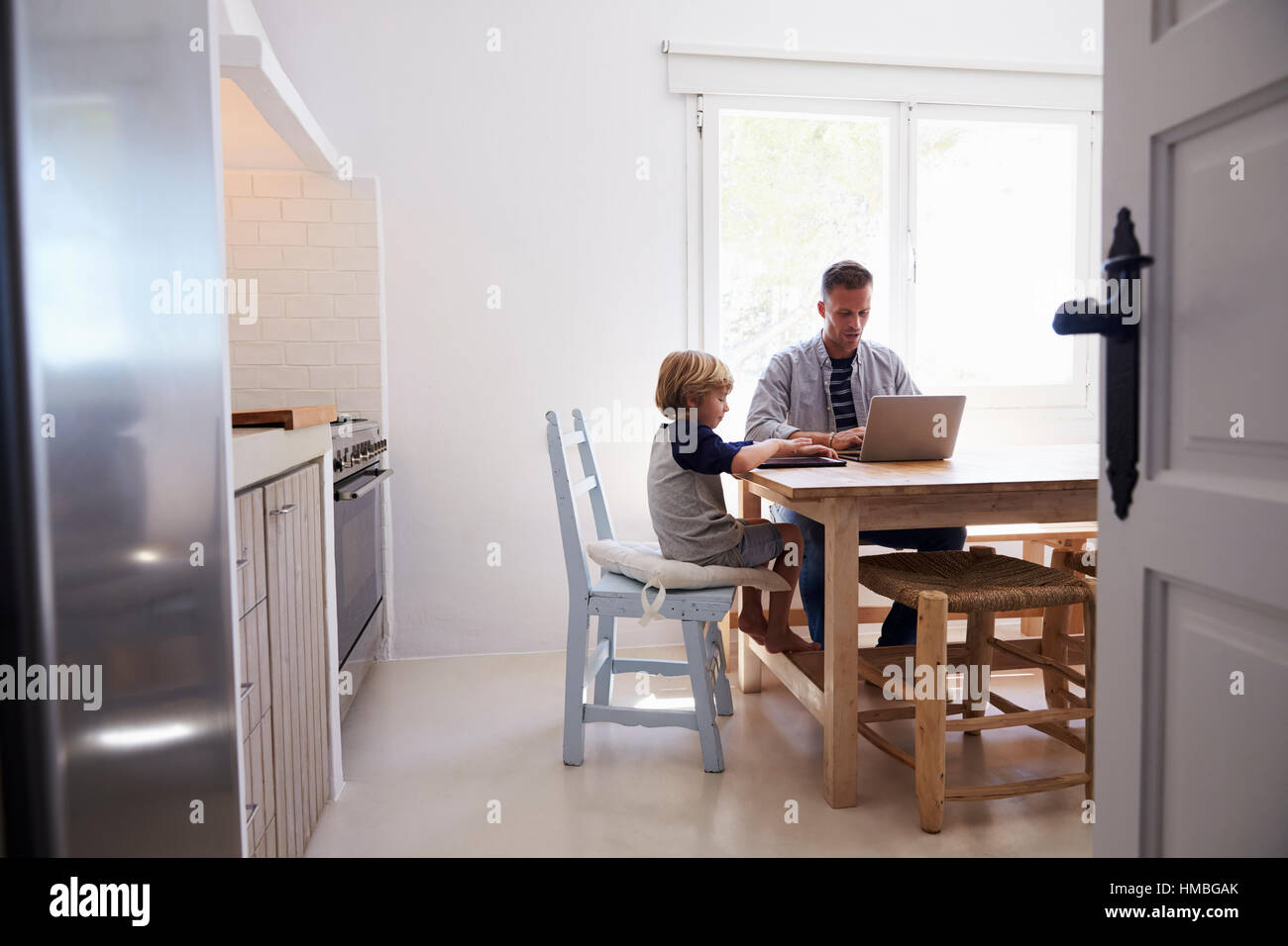 Dad son using computers kitchen table hi-res stock photography and ...