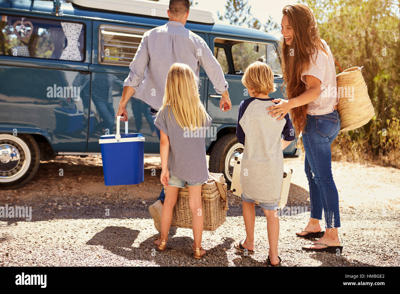 Family preparing their camper van for a road trip, back view Stock ...