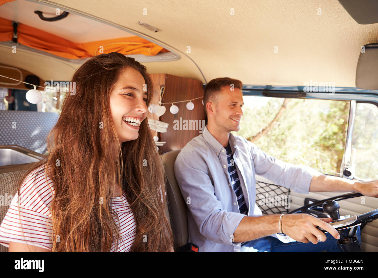 Happy couple driving a camper van on a road trip vacation Stock Photo ...