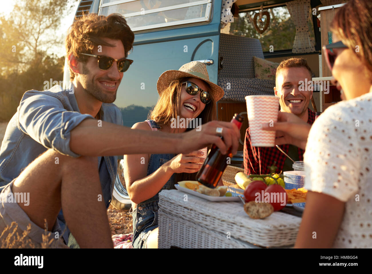 Friends making a toast at a picnic beside their camper van Stock Photo ...