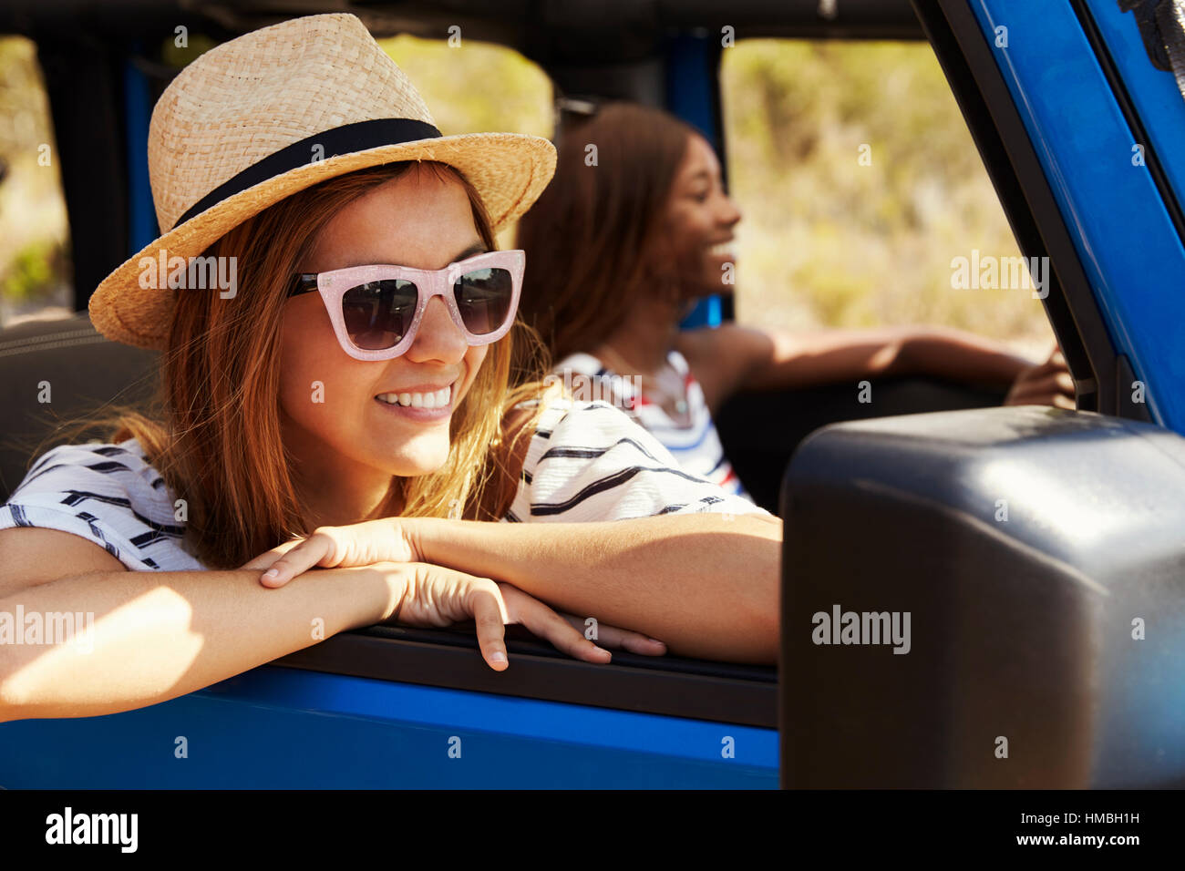 Two Female Friends Driving Open Top Car On Country Road Stock Photo - Alamy