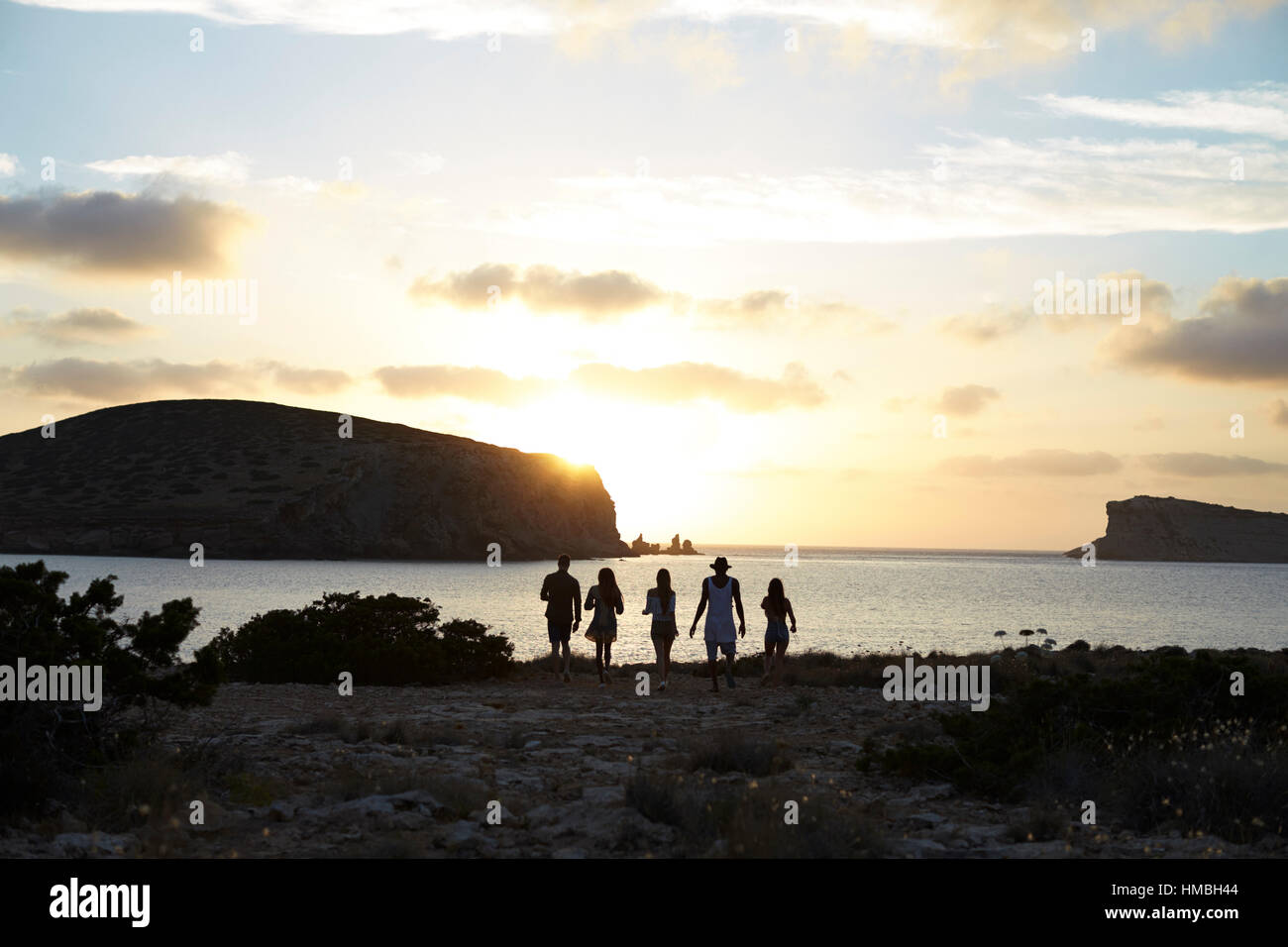 Rear View Of Friends Standing On Cliff Watching Sunset Stock Photo - Alamy