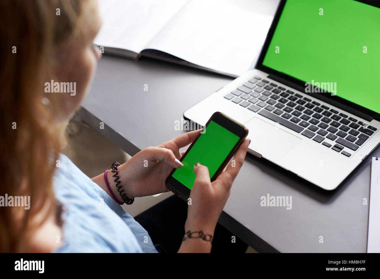 Girl using phone at desk in her bedroom, over shoulder view Stock Photo ...
