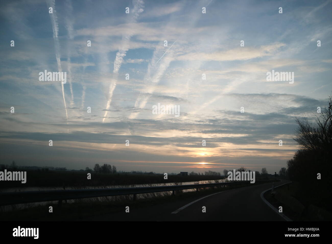 sun behind clouds reflecting on water Stock Photo - Alamy