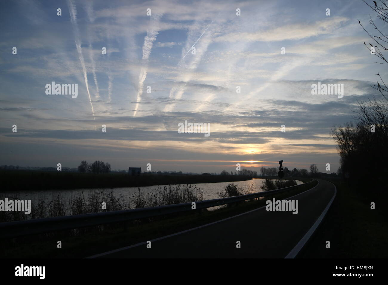 sun behind clouds reflecting on water Stock Photo - Alamy