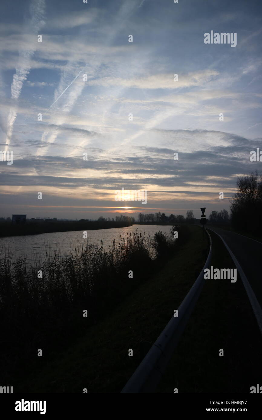 sun behind clouds reflecting on water Stock Photo - Alamy