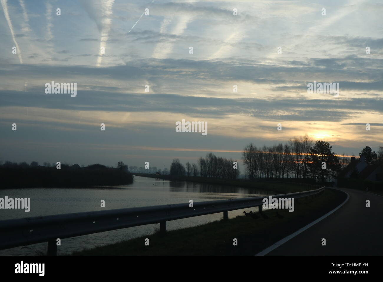 sun behind clouds reflecting on water Stock Photo - Alamy