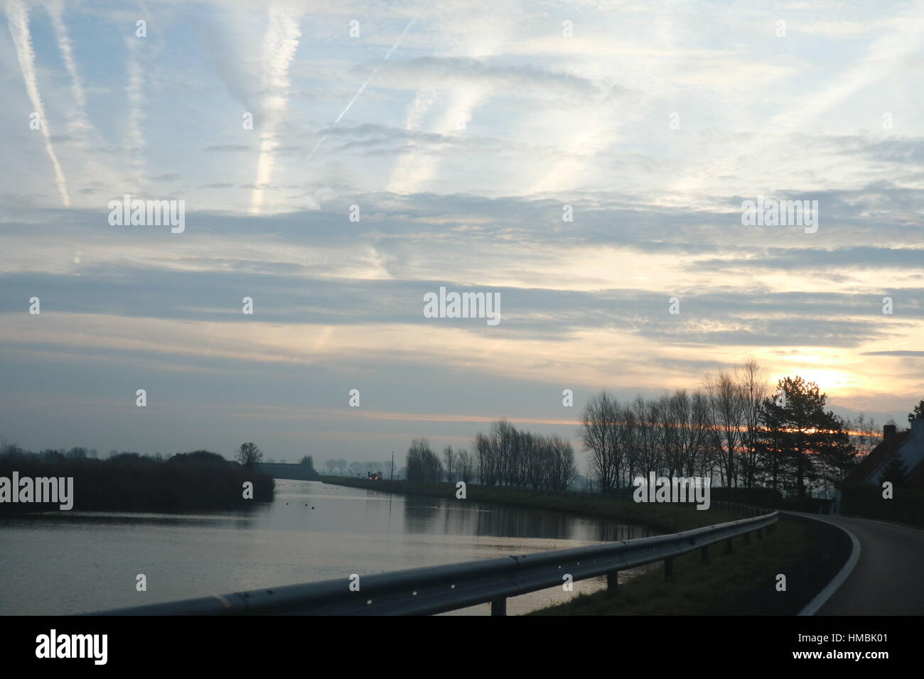 sun behind clouds reflecting on water Stock Photo - Alamy