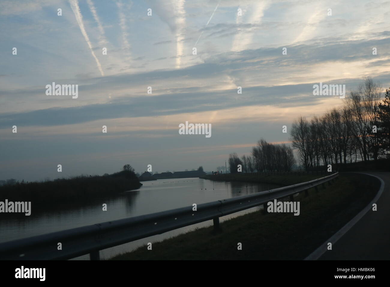 sun behind clouds reflecting on water Stock Photo - Alamy