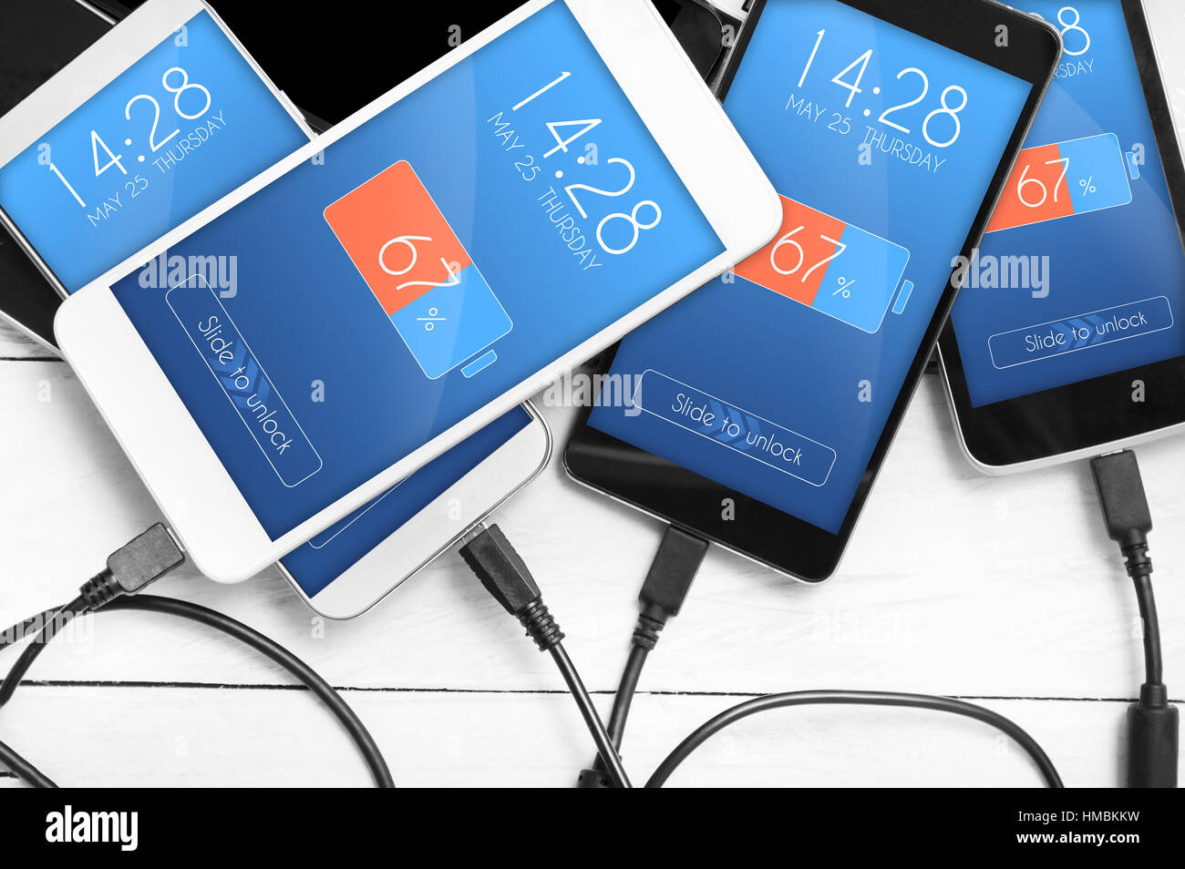 Stack of smartphones connected to power source. Concept of low battery ...