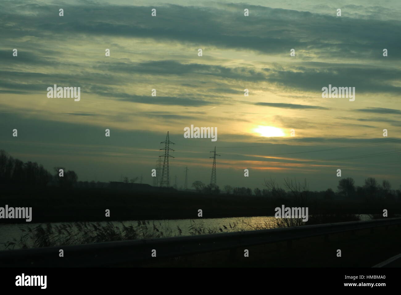 sun behind clouds reflecting on water Stock Photo - Alamy