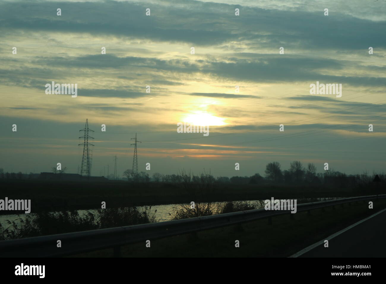 sun behind clouds reflecting on water Stock Photo - Alamy