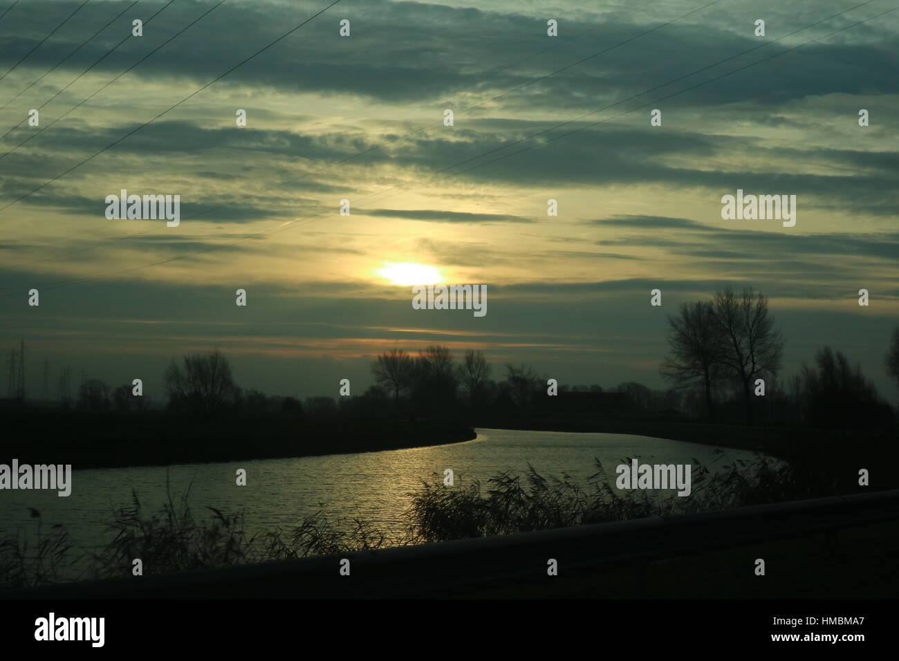 sun behind clouds reflecting on water Stock Photo - Alamy