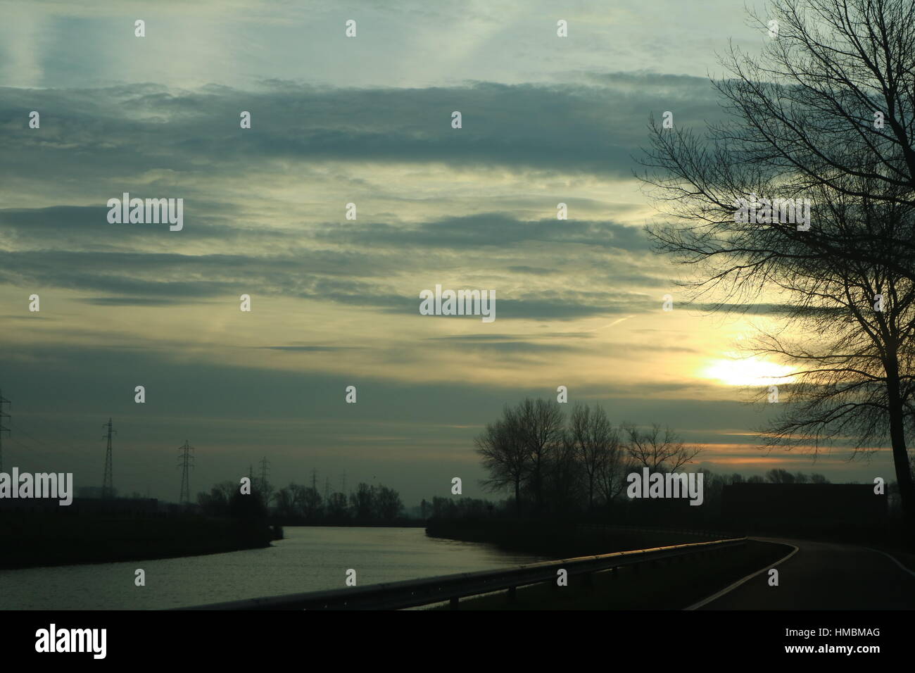 sun behind clouds reflecting on water Stock Photo - Alamy