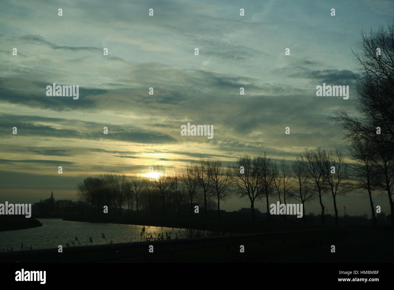 sun behind clouds reflecting on water Stock Photo - Alamy