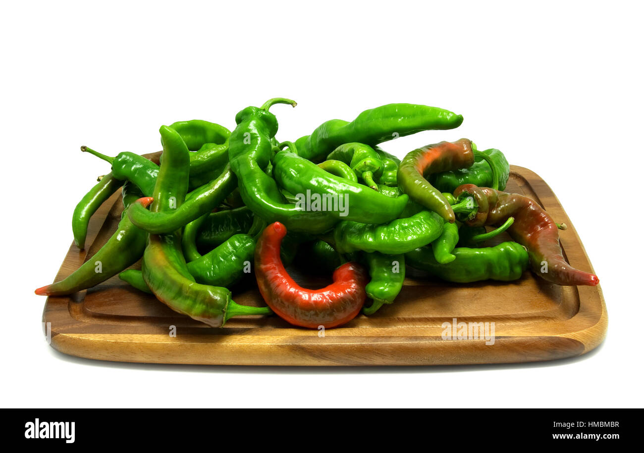Multicolor hot peppers on wooden kitchen board. Isolated on white ...