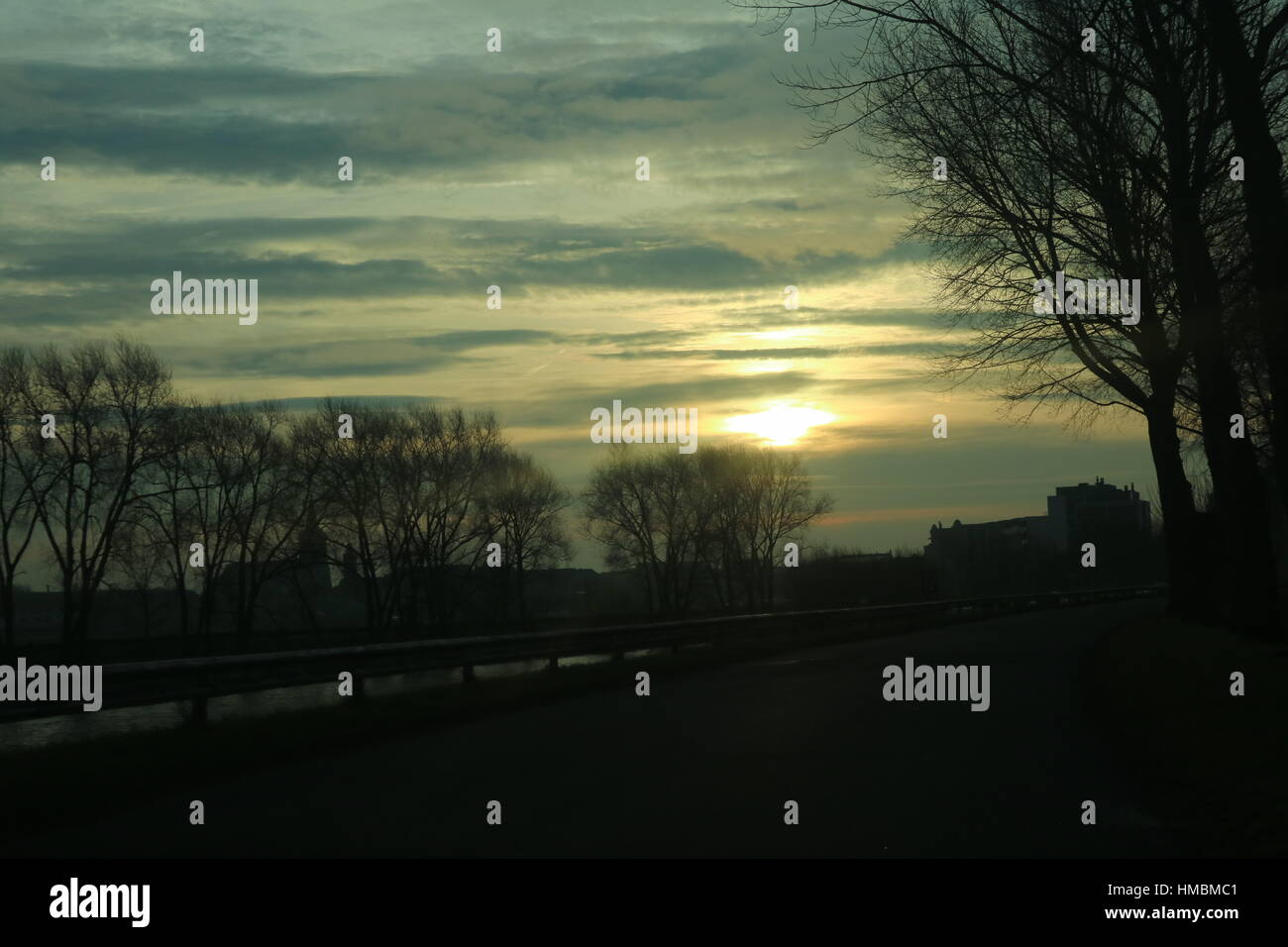 sun behind clouds reflecting on water Stock Photo - Alamy