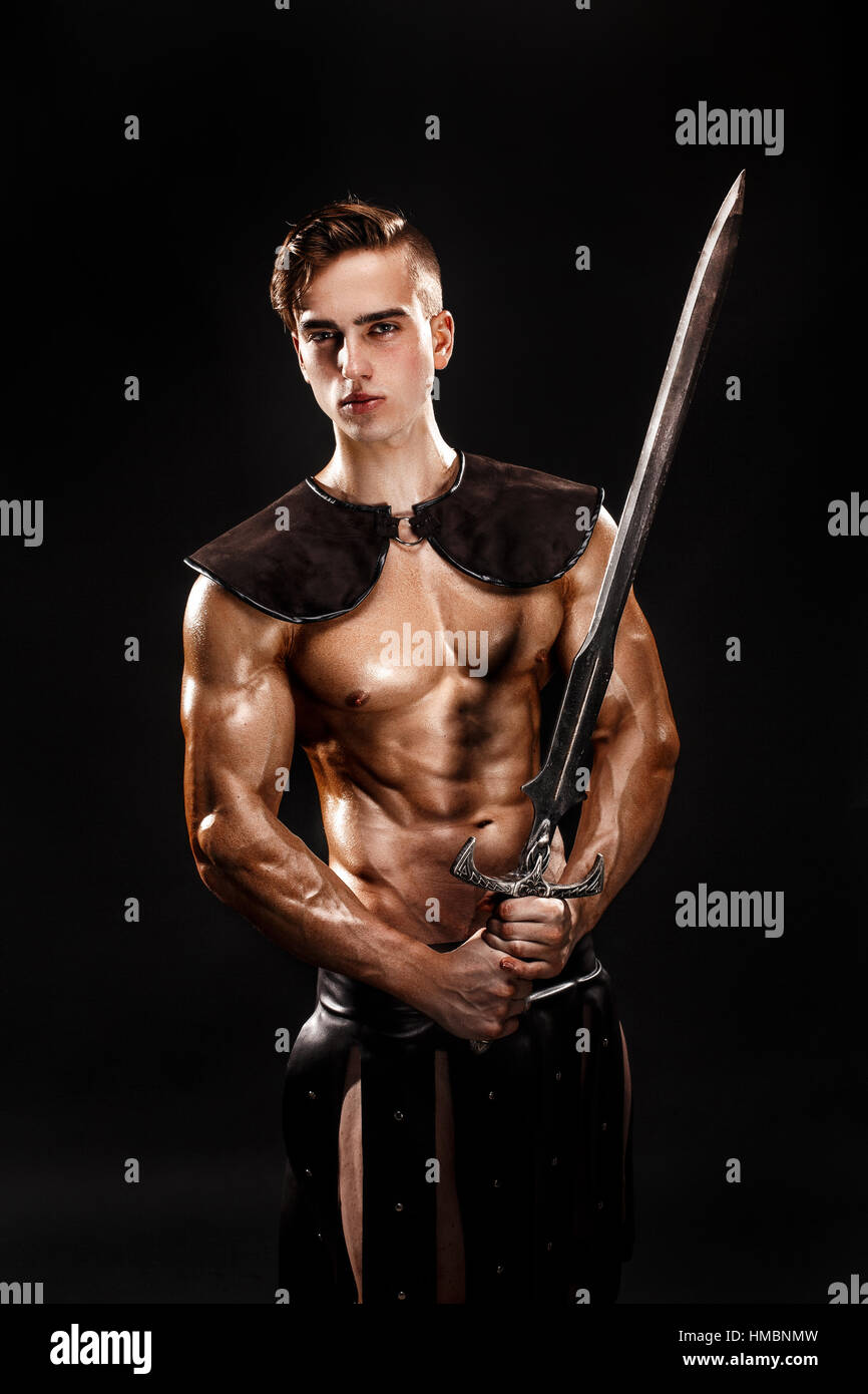 Portrait of handsome muscular gladiator with sword. Isolated. Studio ...