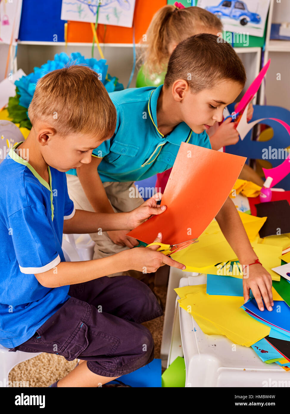 Child cutting paper in class. Development social lerning in school ...