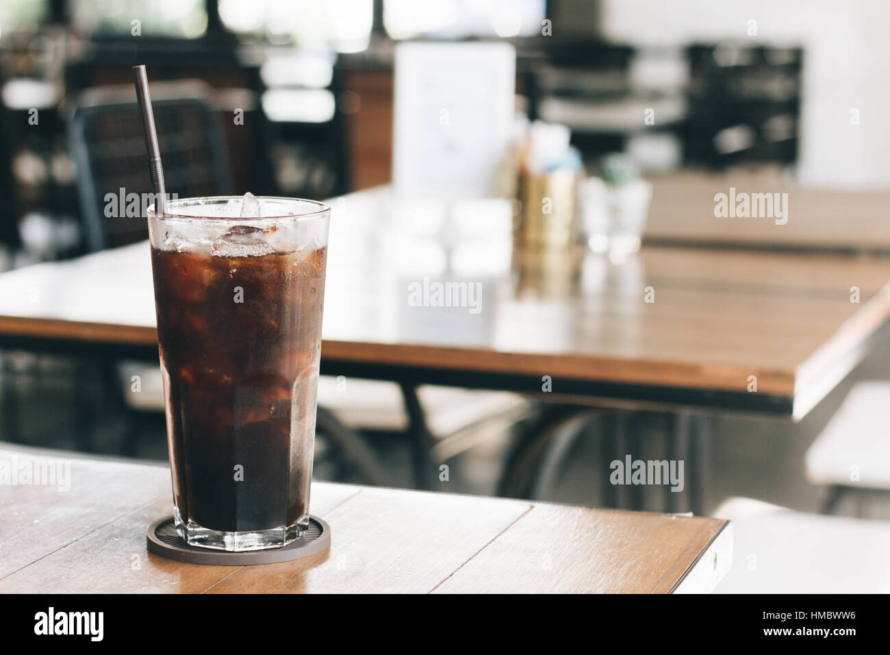 Cold black coffee on the table in the coffee shop with vintage filter ...