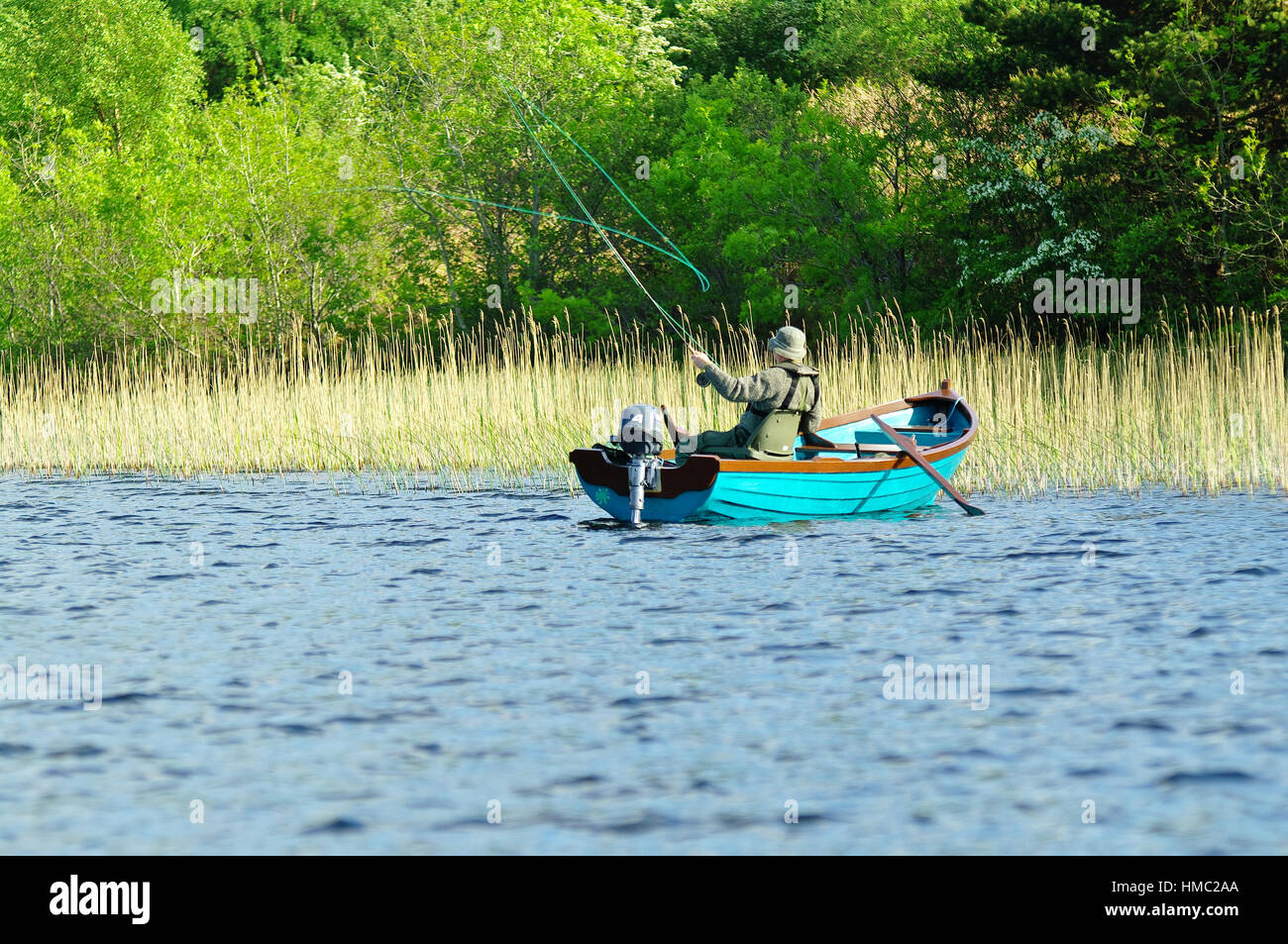 Fly fishing from a boat on Irish lake Stock Photo - Alamy
