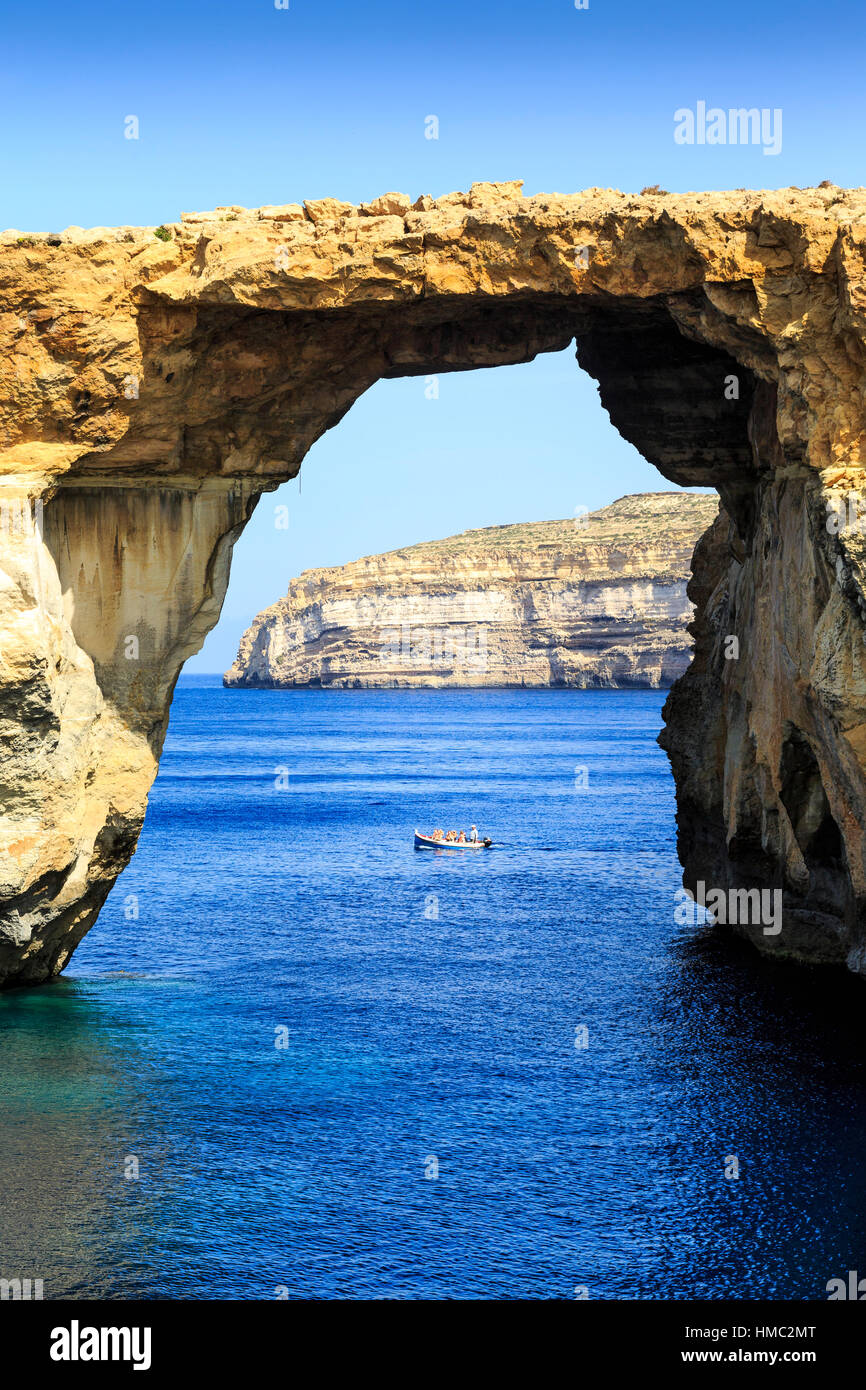 excursion boats travelling through the azure window natural arch in ...