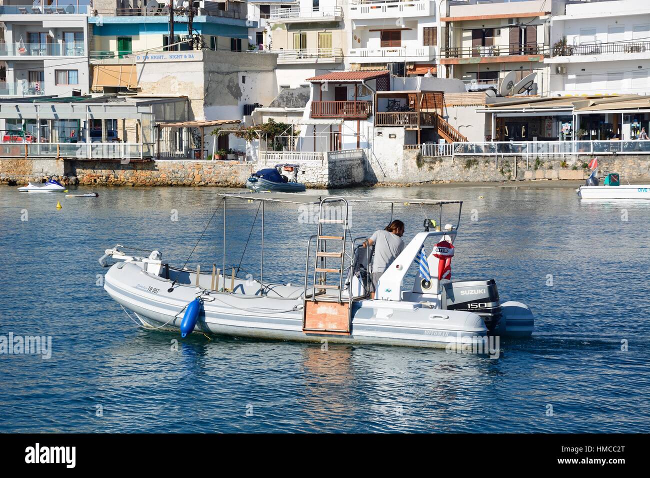 Rigid inflatable boat in the harbour with views towards waterfront ...