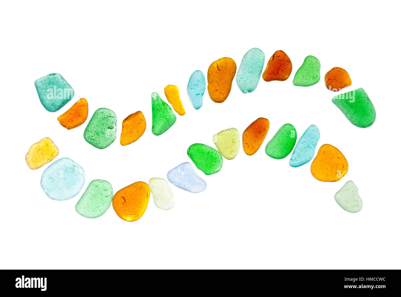 backlit sea glass peices isolated on white background, shape of a wave ...