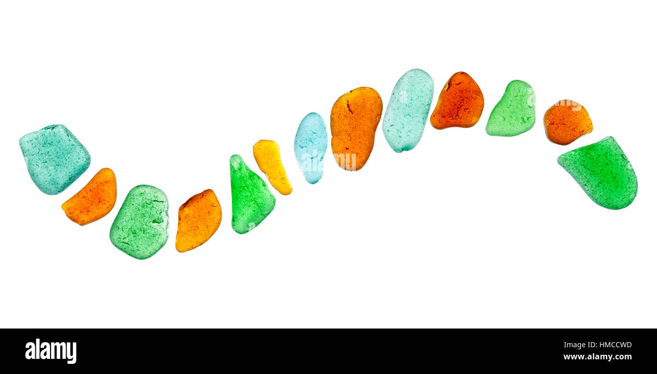 backlit sea glass peices isolated on white background, shape of a wave ...