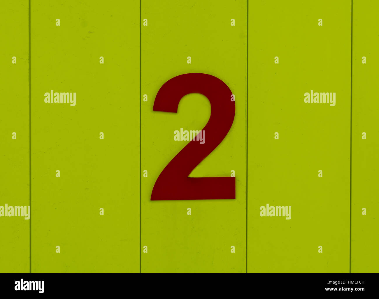 The number two (2), in red, on a yellow surface which is made out of ...