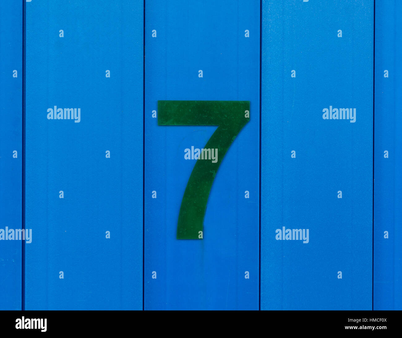 The number seven (7), in green, on a blur surface which is made out of ...