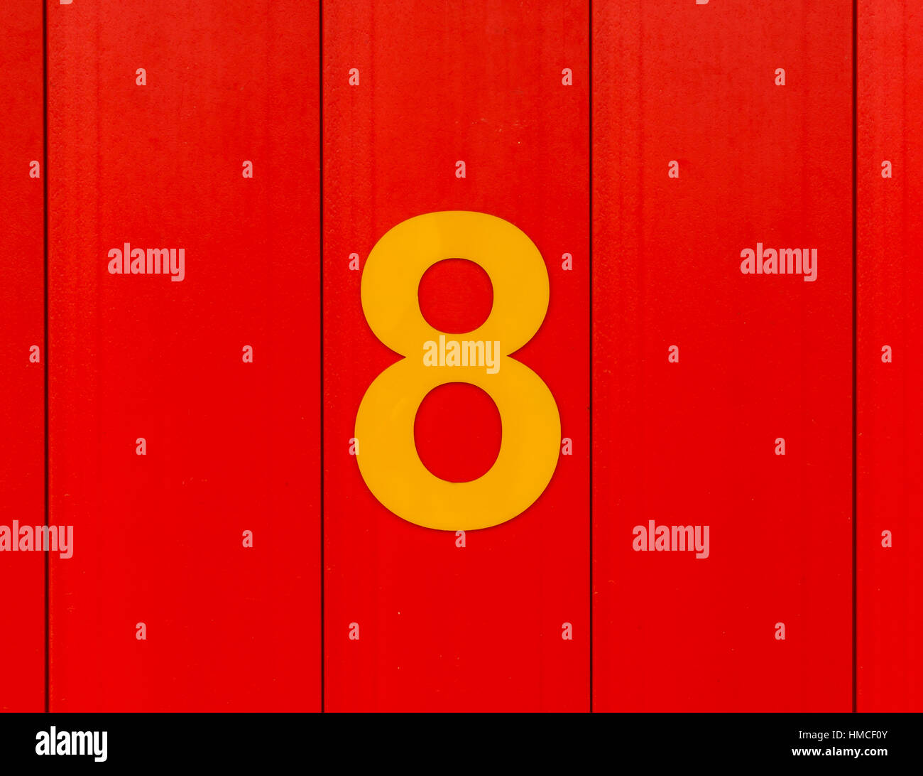The number eight (8), in yellow, on a red surface which is made out of ...