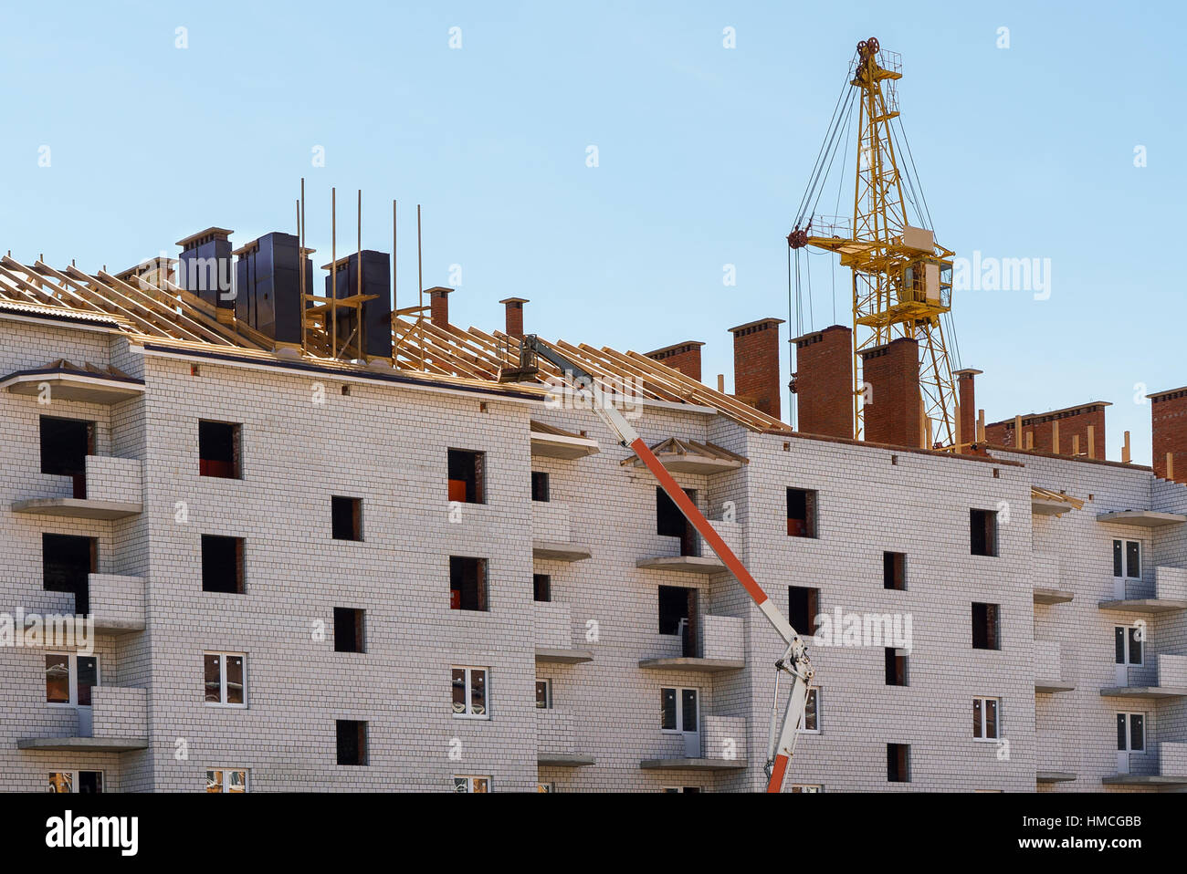 Construction of multistory building. Covering roof Stock Photo - Alamy