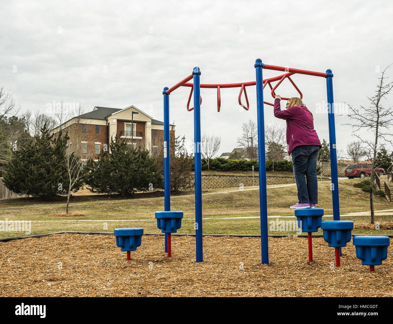 Young girl climbing on playground equipment at the park Stock Photo - Alamy