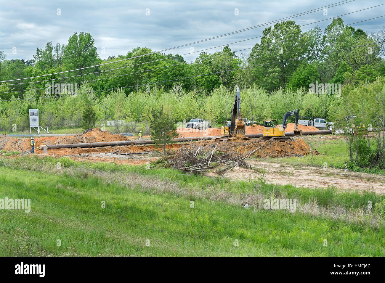 Workers at a construction site prepare to bury a large metal pipe Stock ...