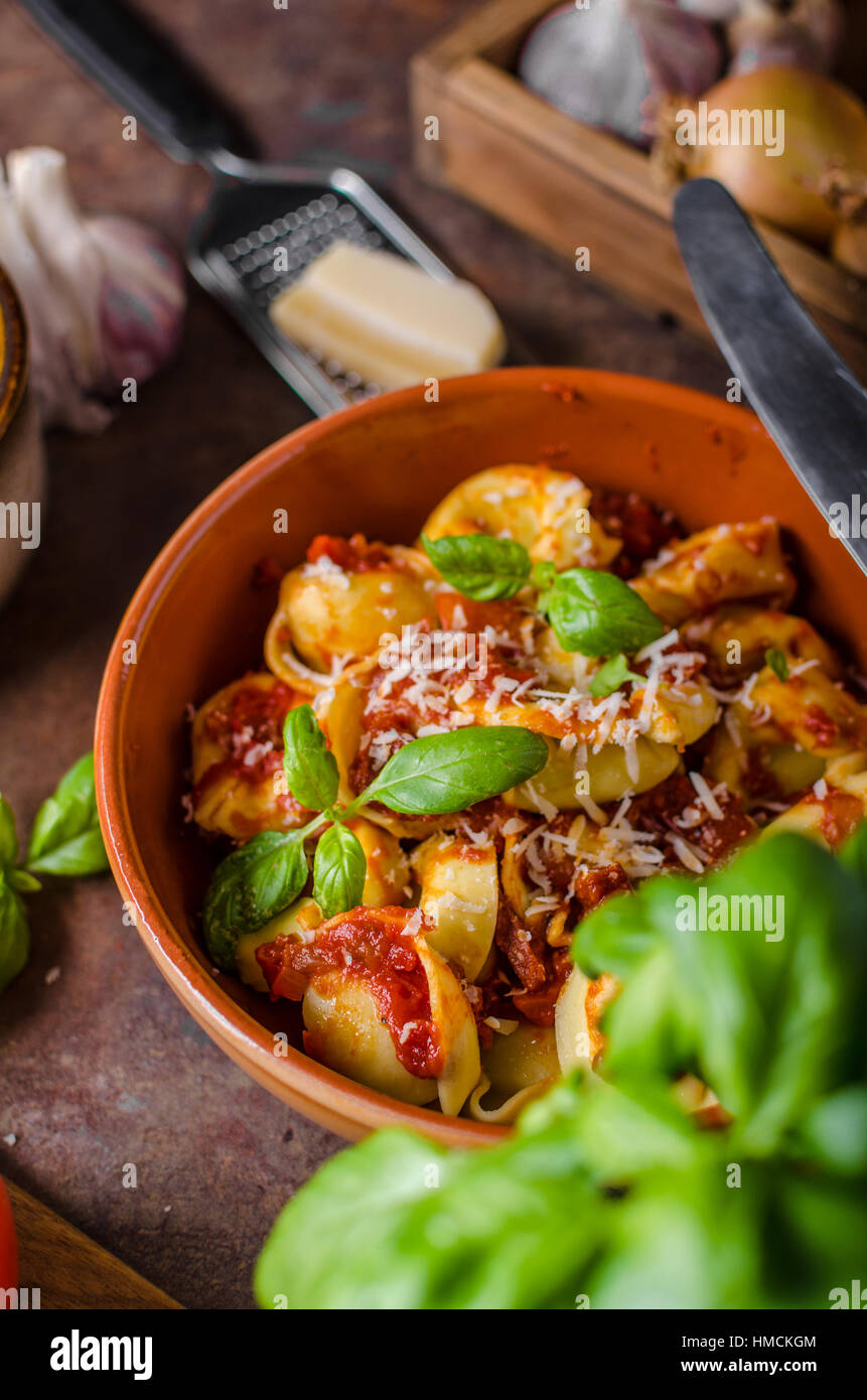Homemade tortellini with tomato sauce, herbs and garlic in, topped with parmesan cheese Stock ...