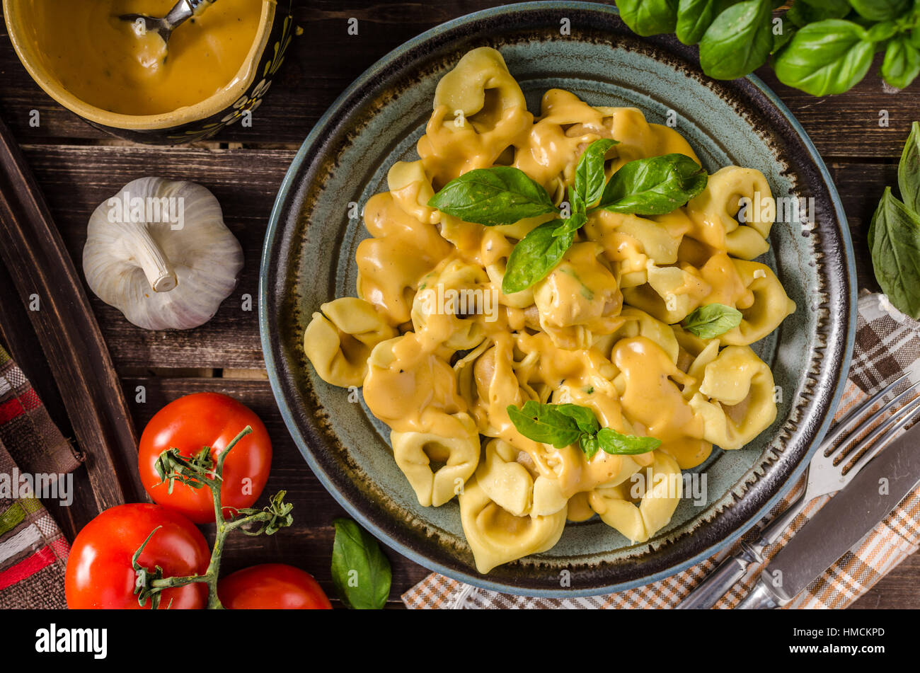 Tortellini with cheese sauce, basil and herbs Stock Photo - Alamy