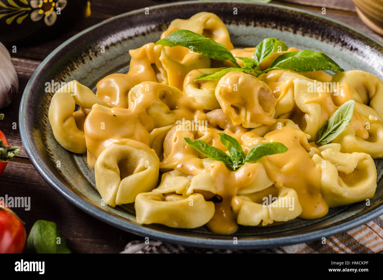 Tortellini with cheese sauce, basil and herbs Stock Photo - Alamy