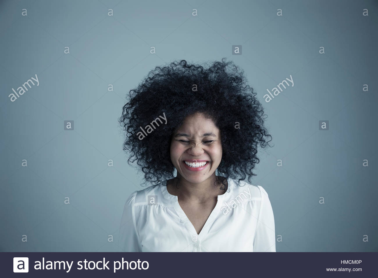 Portrait enthusiastic mixed race young woman with curly black afro hair ...