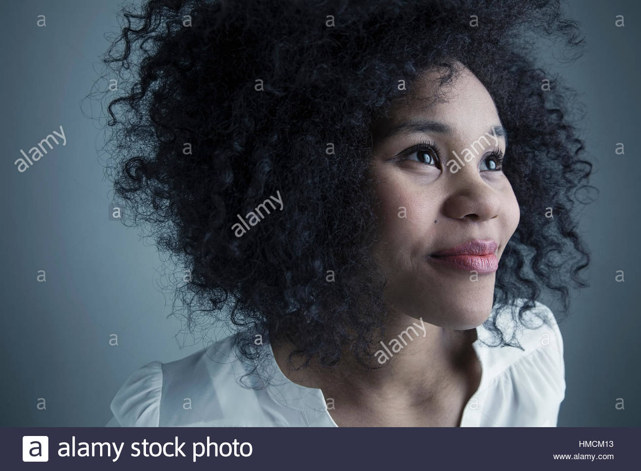 Close up portrait hopeful mixed race young woman with curly black afro ...
