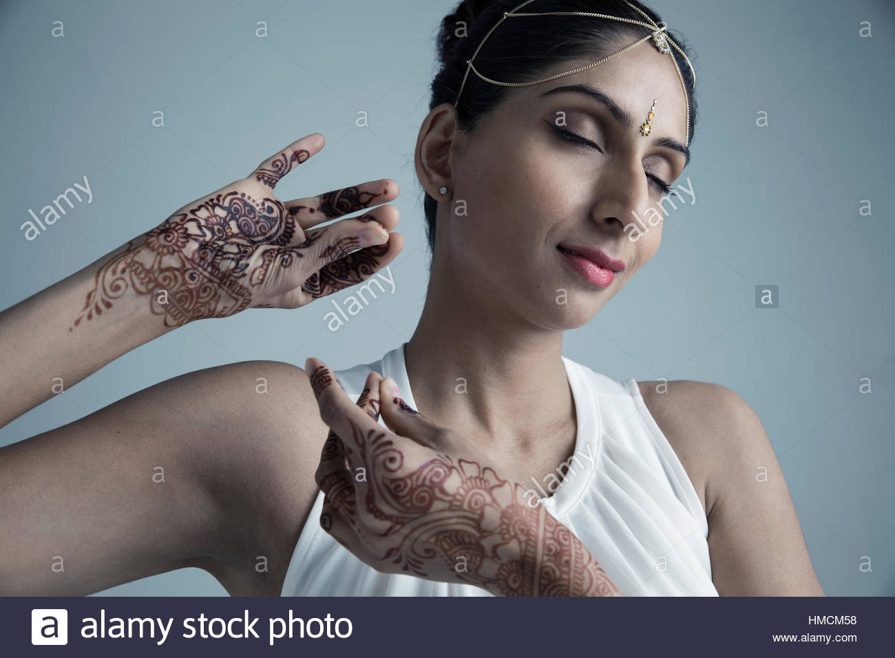 Portrait serene Indian mid adult woman with henna tattoos, bindi and ...