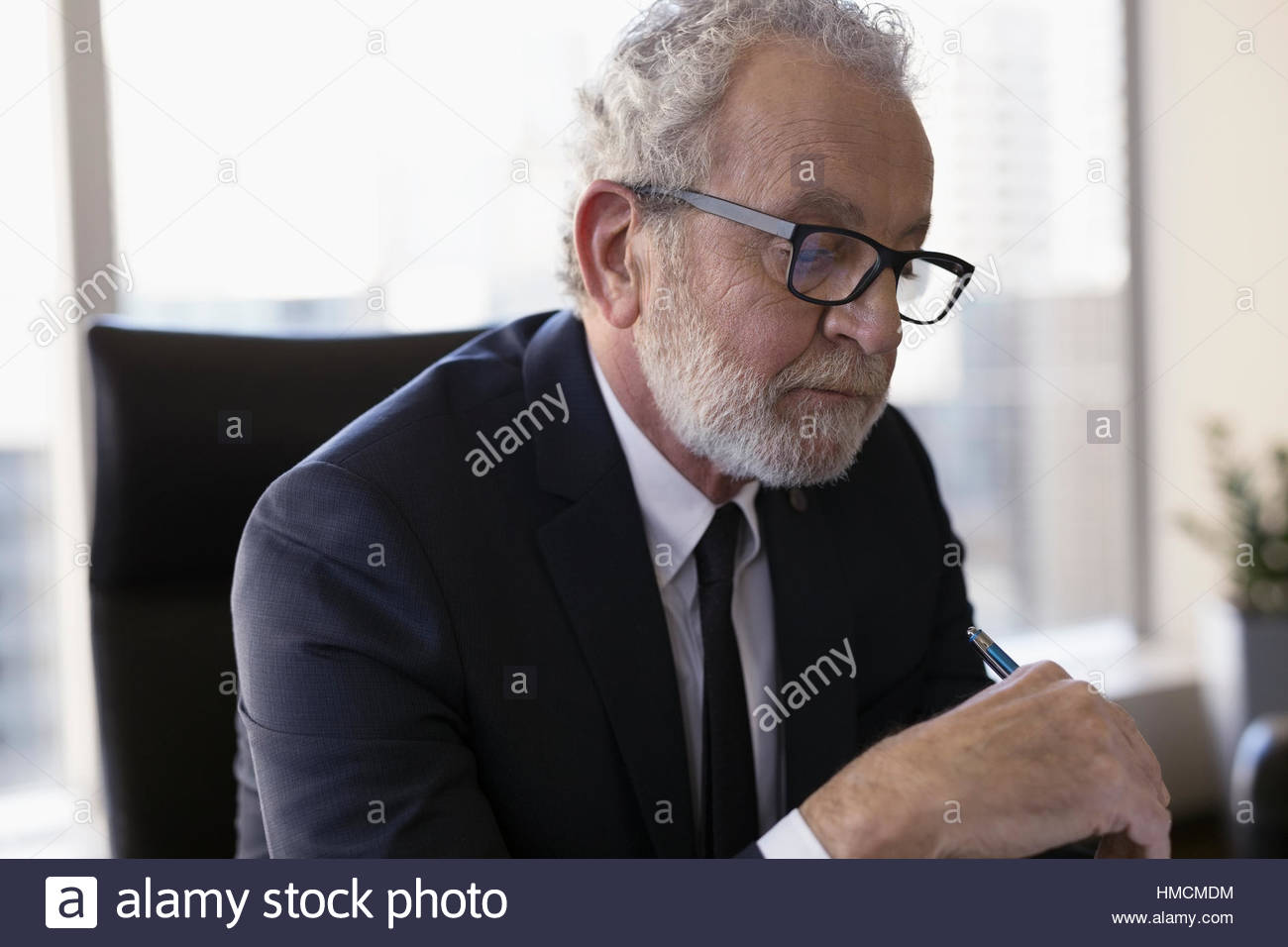 Serious senior male lawyer reading Stock Photo - Alamy