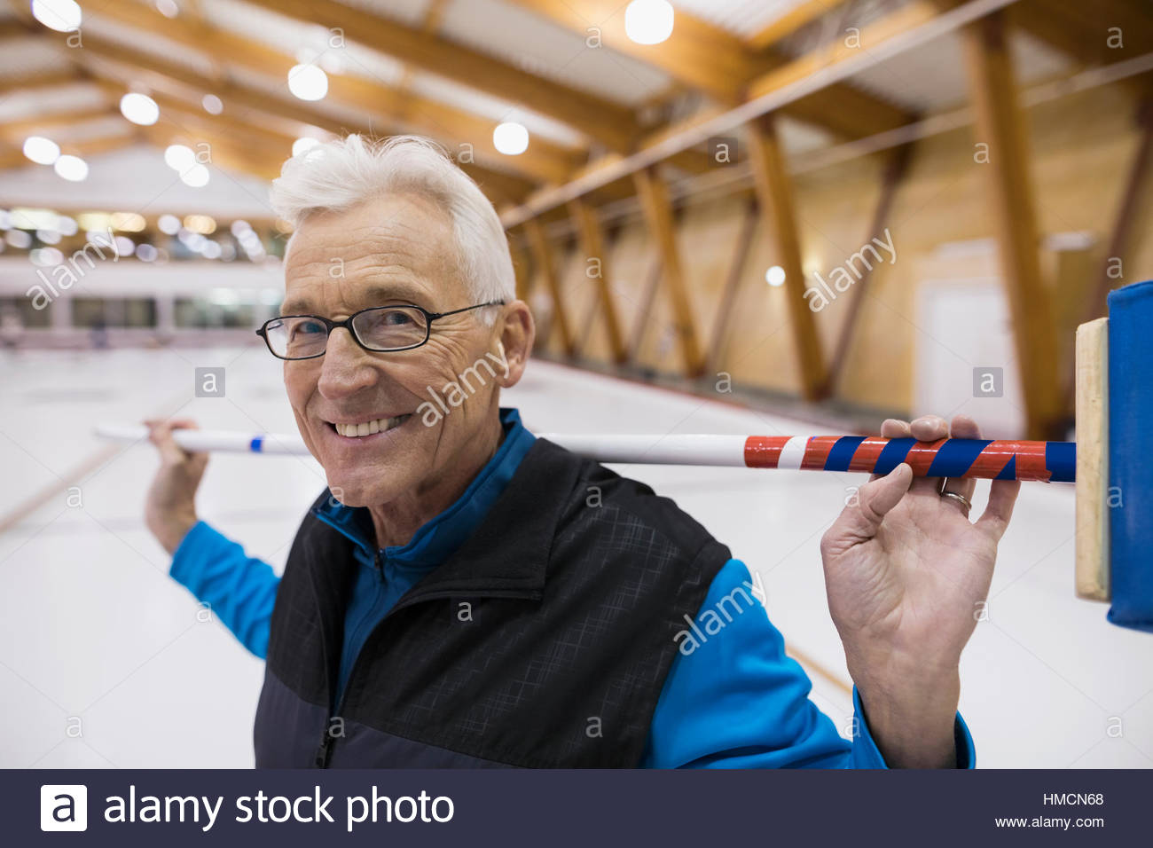 Portrait smiling senior man holding curling broom at curling club Stock ...